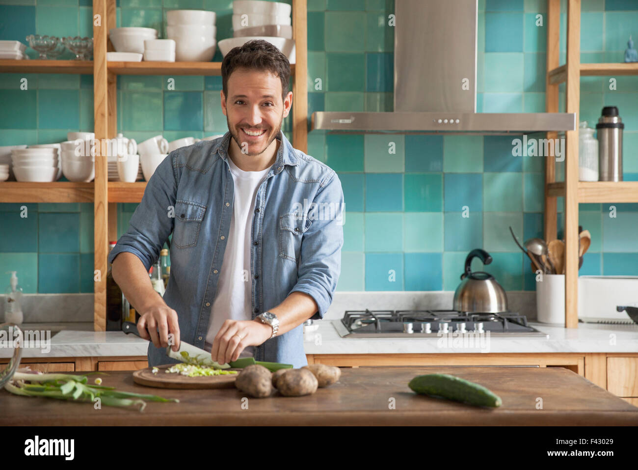Man cutting up ingredients in kitchen, portrait Stock Photo - Alamy