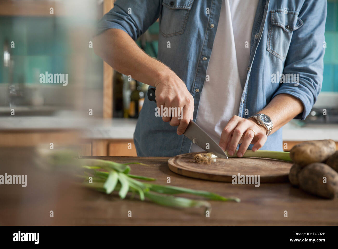 Man cutting spring onion Stock Photo - Alamy
