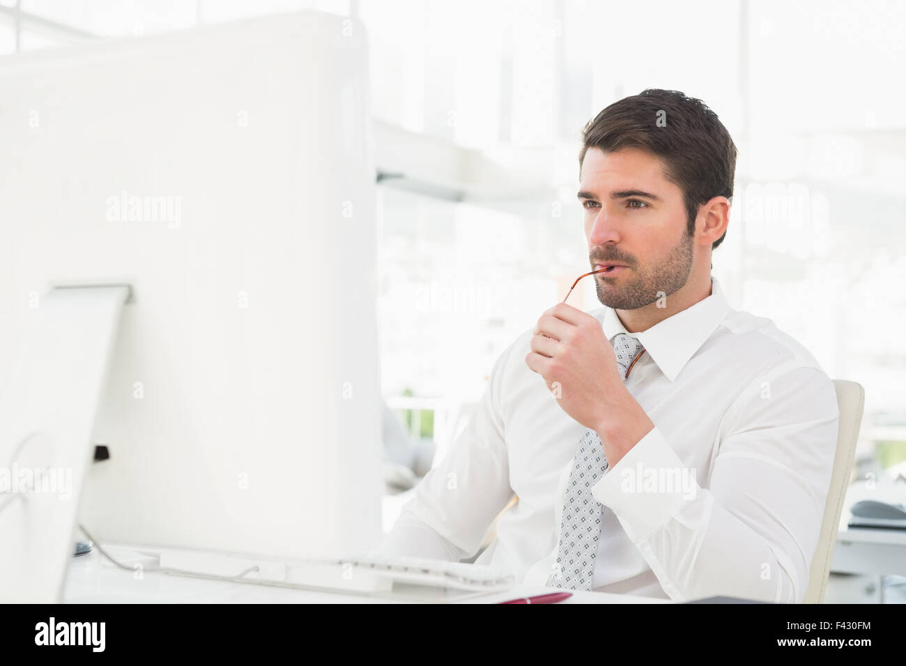 Serious businessman using computer monitor Stock Photo - Alamy