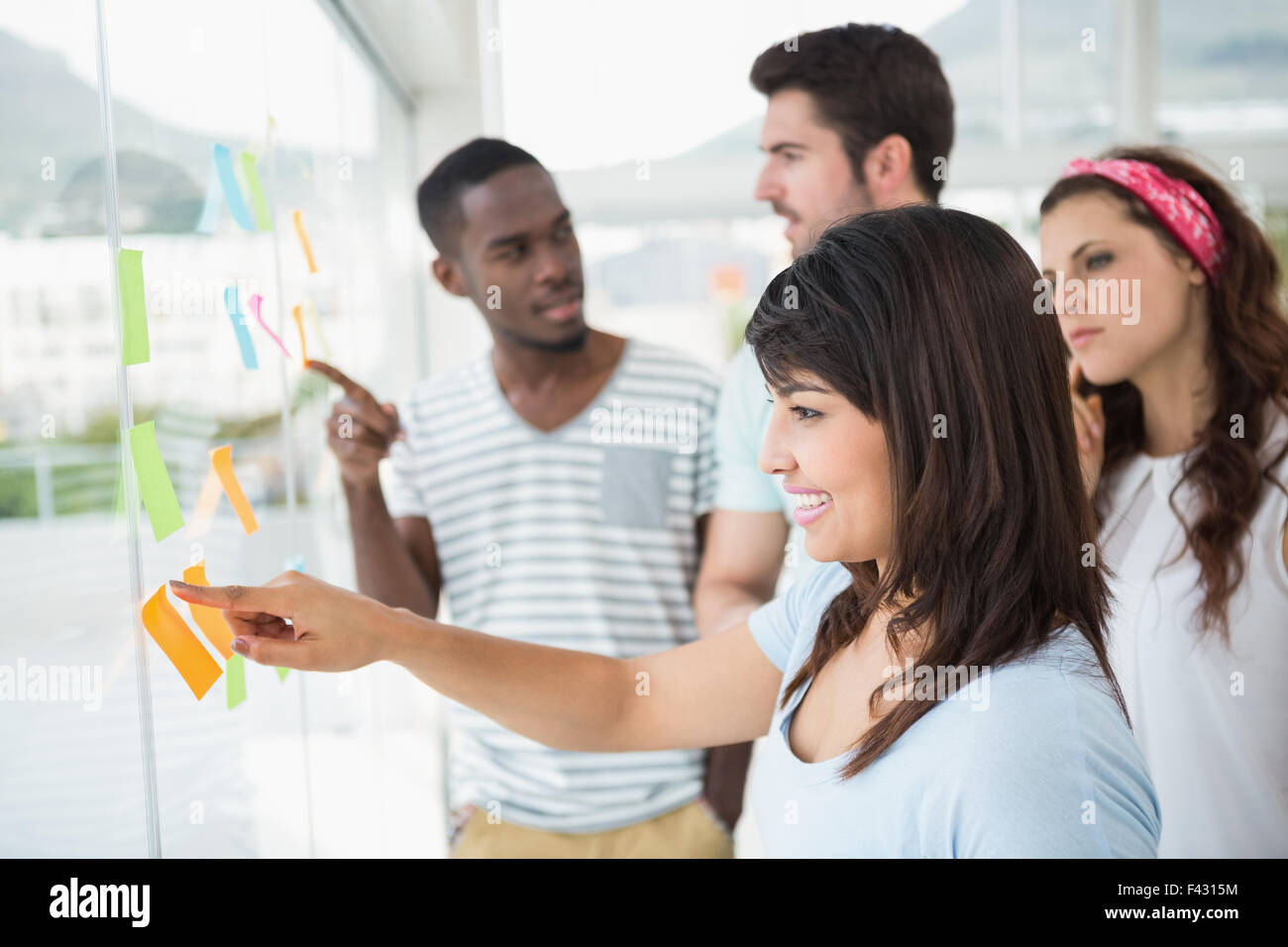 Teamwork pointing and reading sticky notes Stock Photo - Alamy