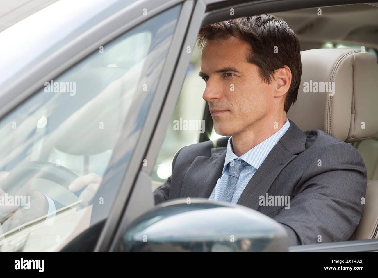 Businessman driving car Stock Photo - Alamy