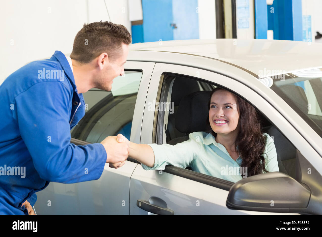 Customer shaking hands with mechanic Stock Photo - Alamy