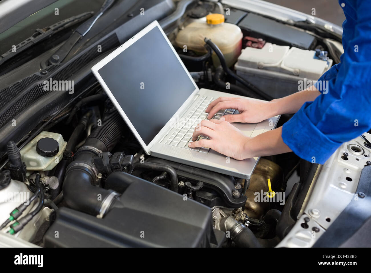 Mechanic using laptop on car Stock Photo - Alamy