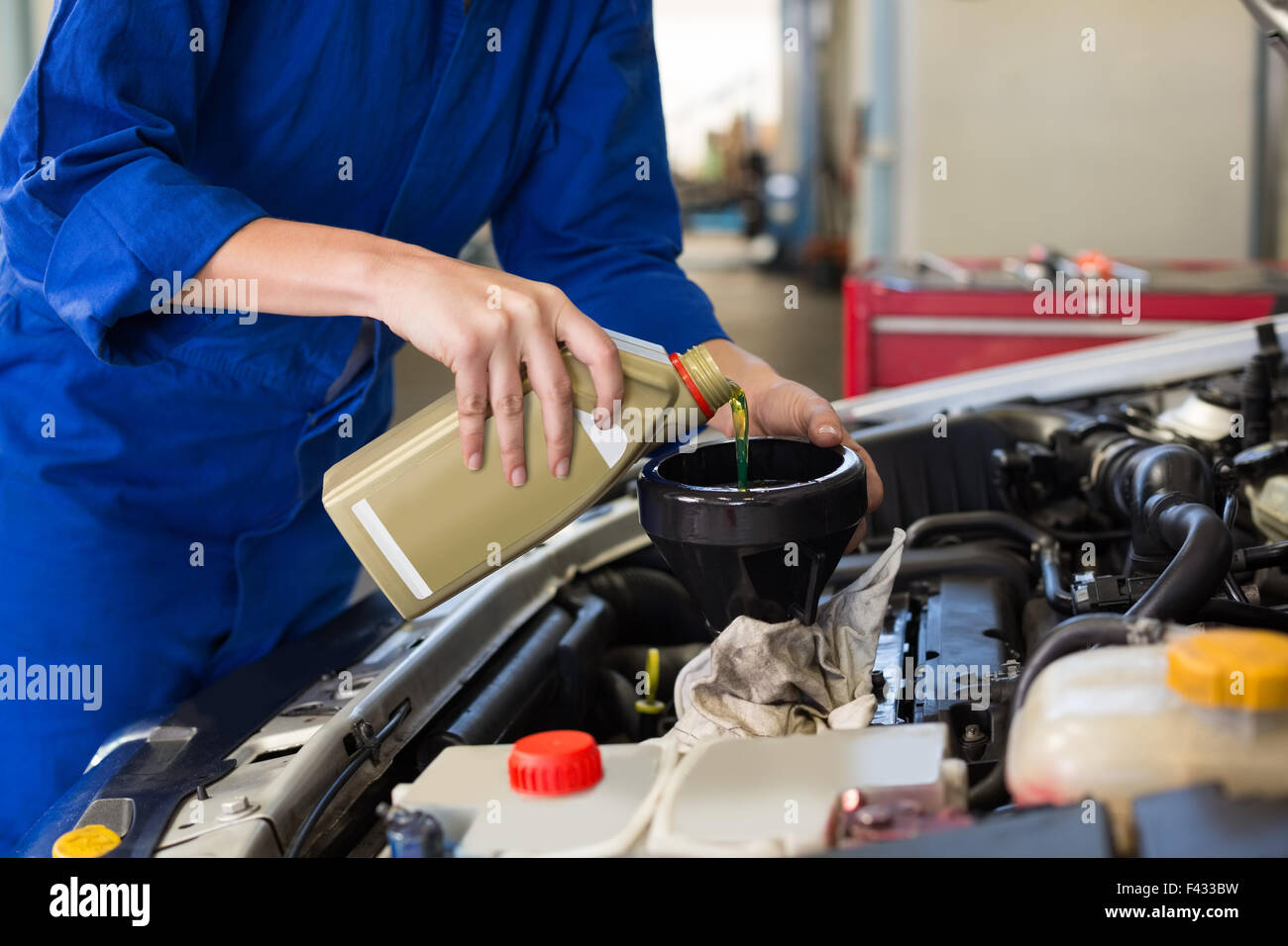 Mechanic pouring oil into car Stock Photo - Alamy