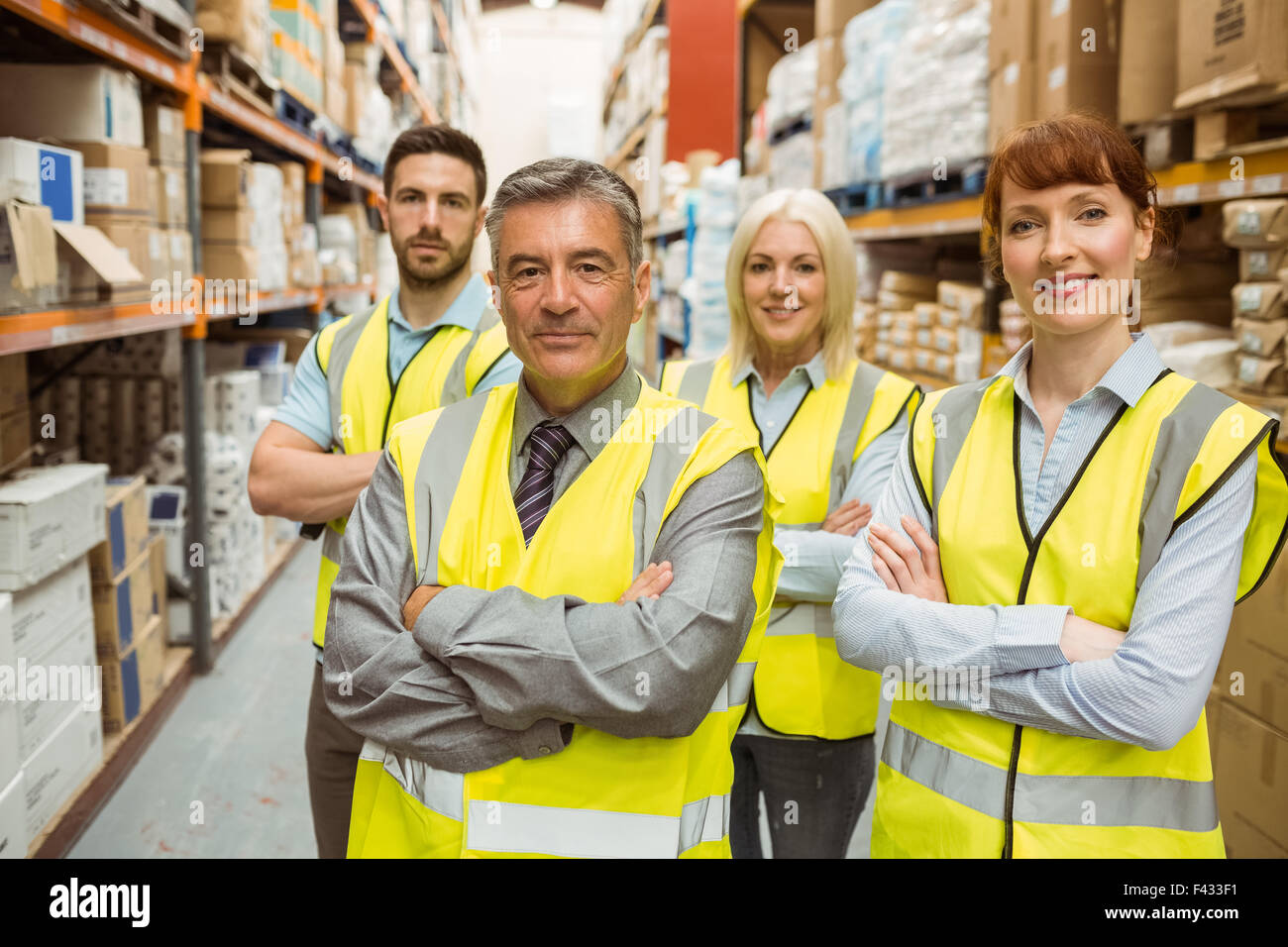 Smiling warehouse team with arms crossed Stock Photo - Alamy