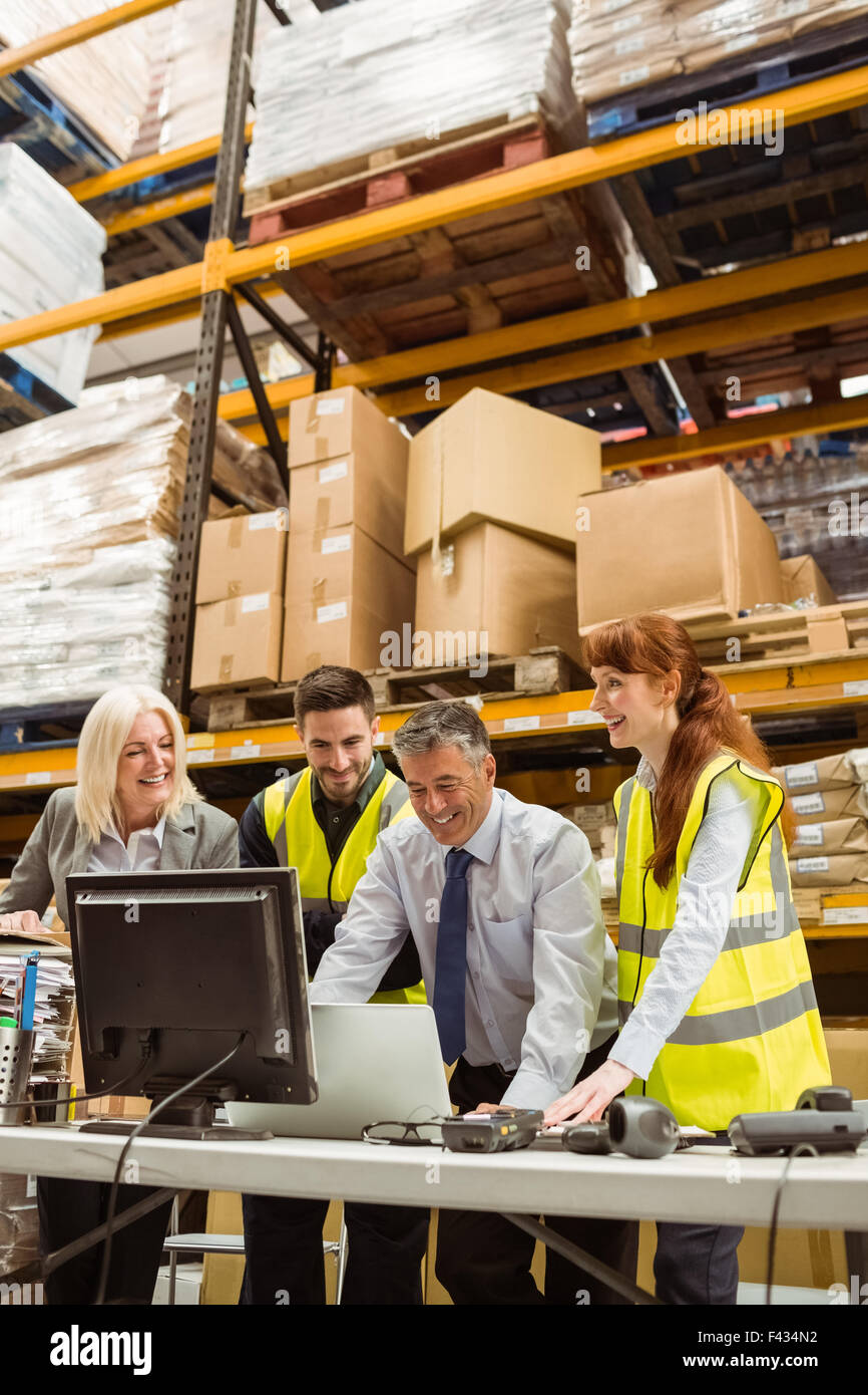 Warehouse team working together on laptop Stock Photo - Alamy