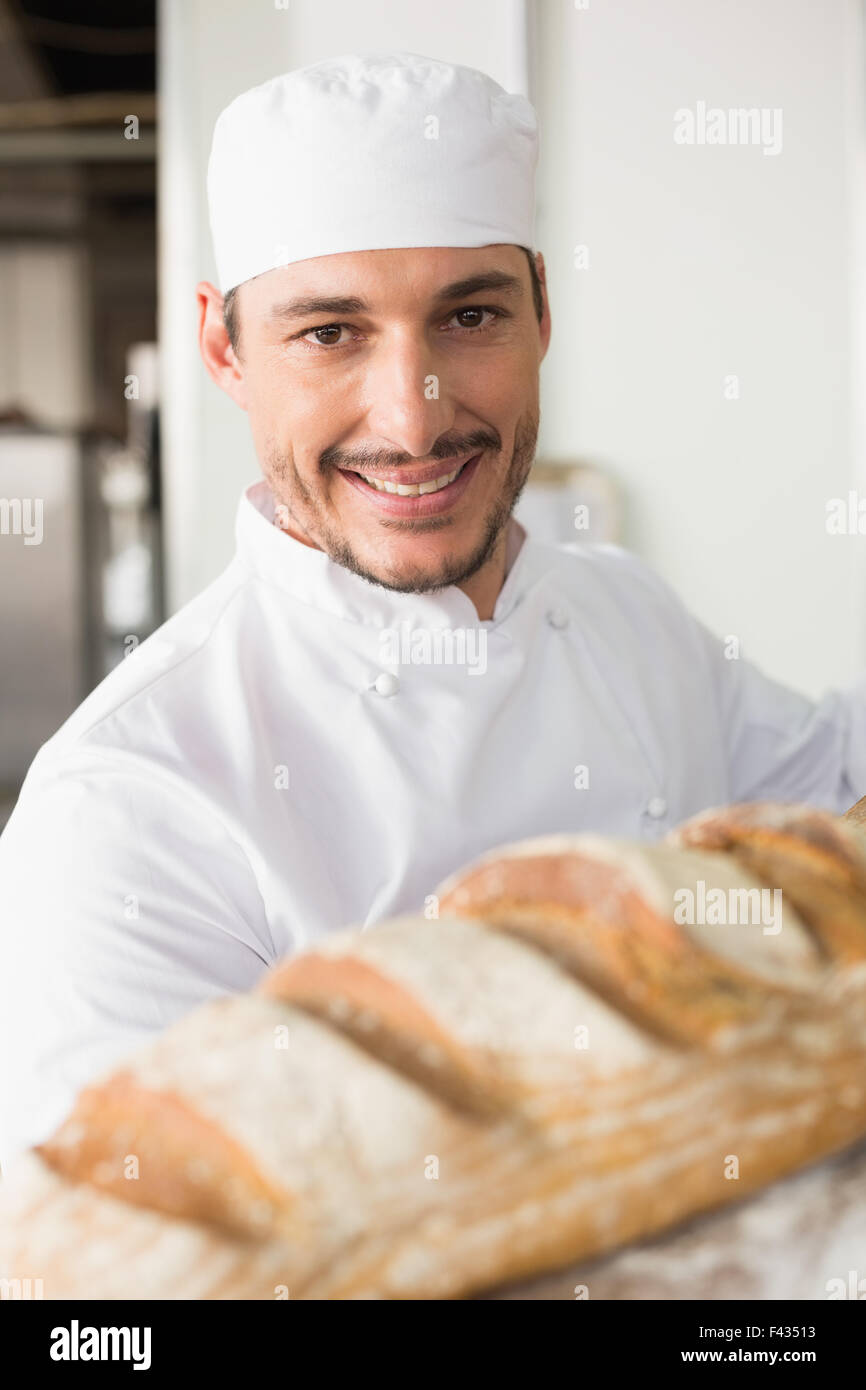 Happy baker taking out fresh loaf Stock Photo - Alamy