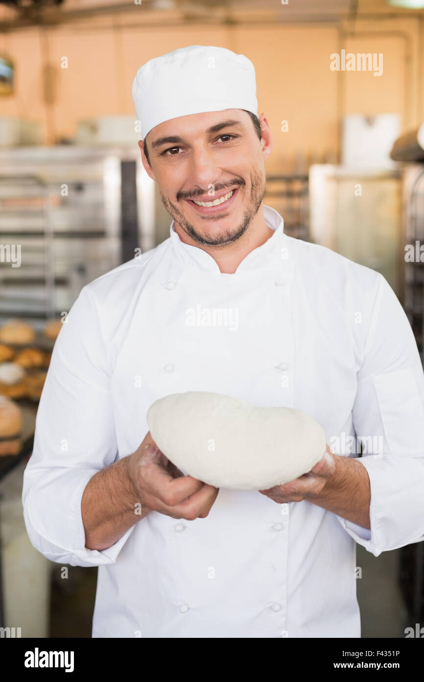 Smiling baker holding raw dough Stock Photo - Alamy