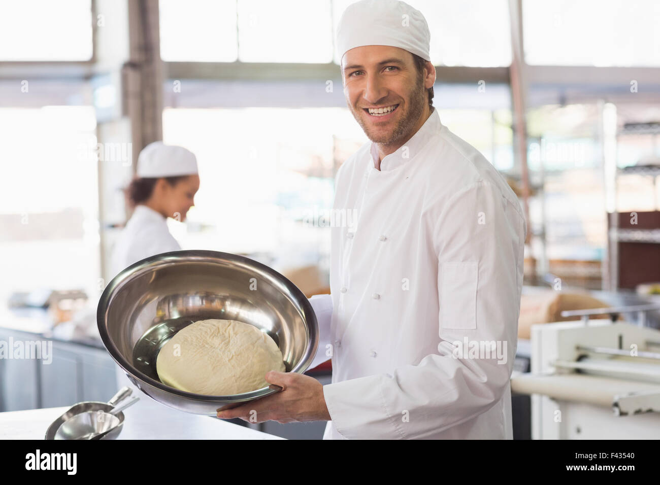 Baker showing dough in mixing bowl Stock Photo - Alamy