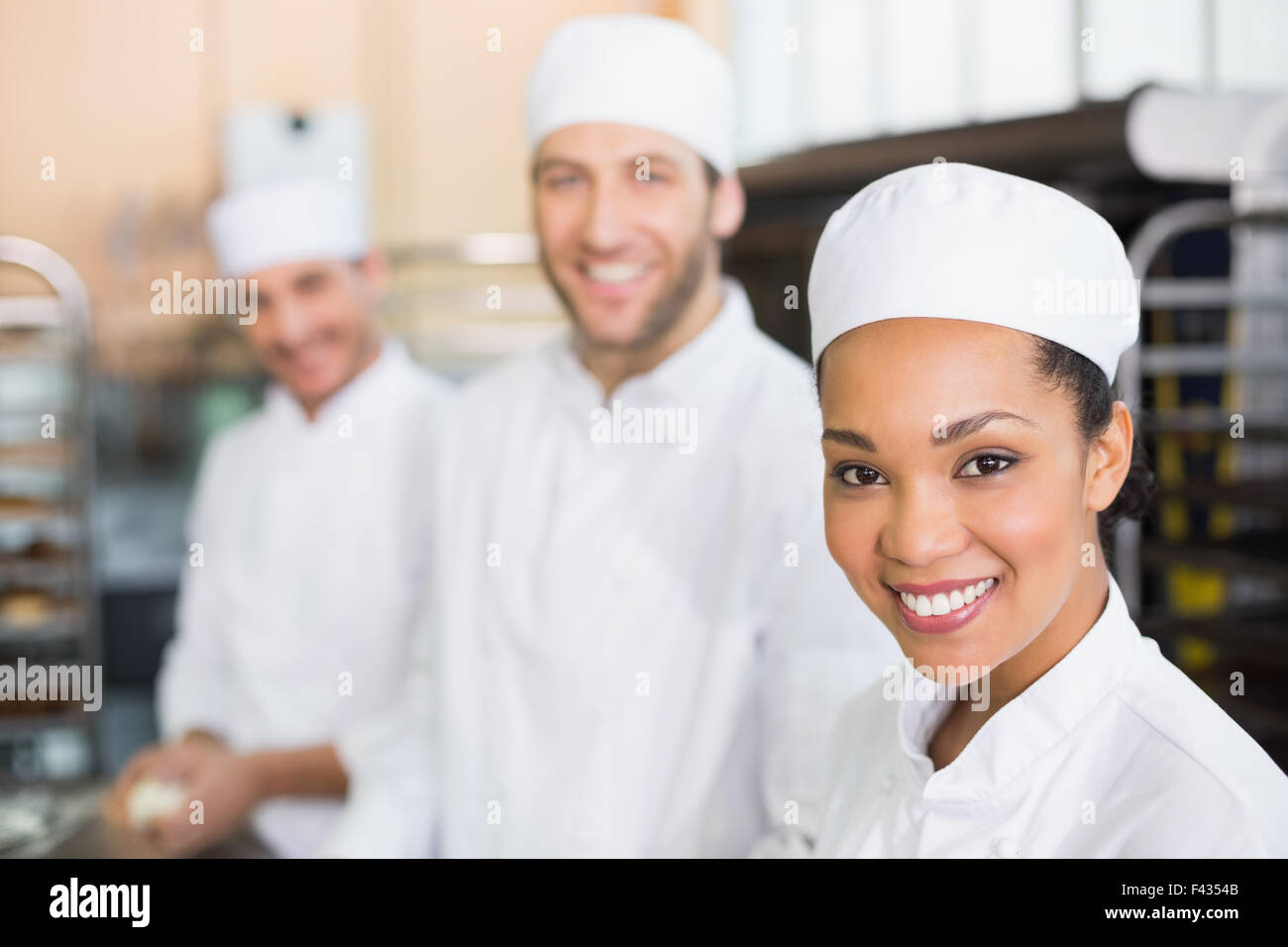 Team of bakers smiling at camera Stock Photo - Alamy