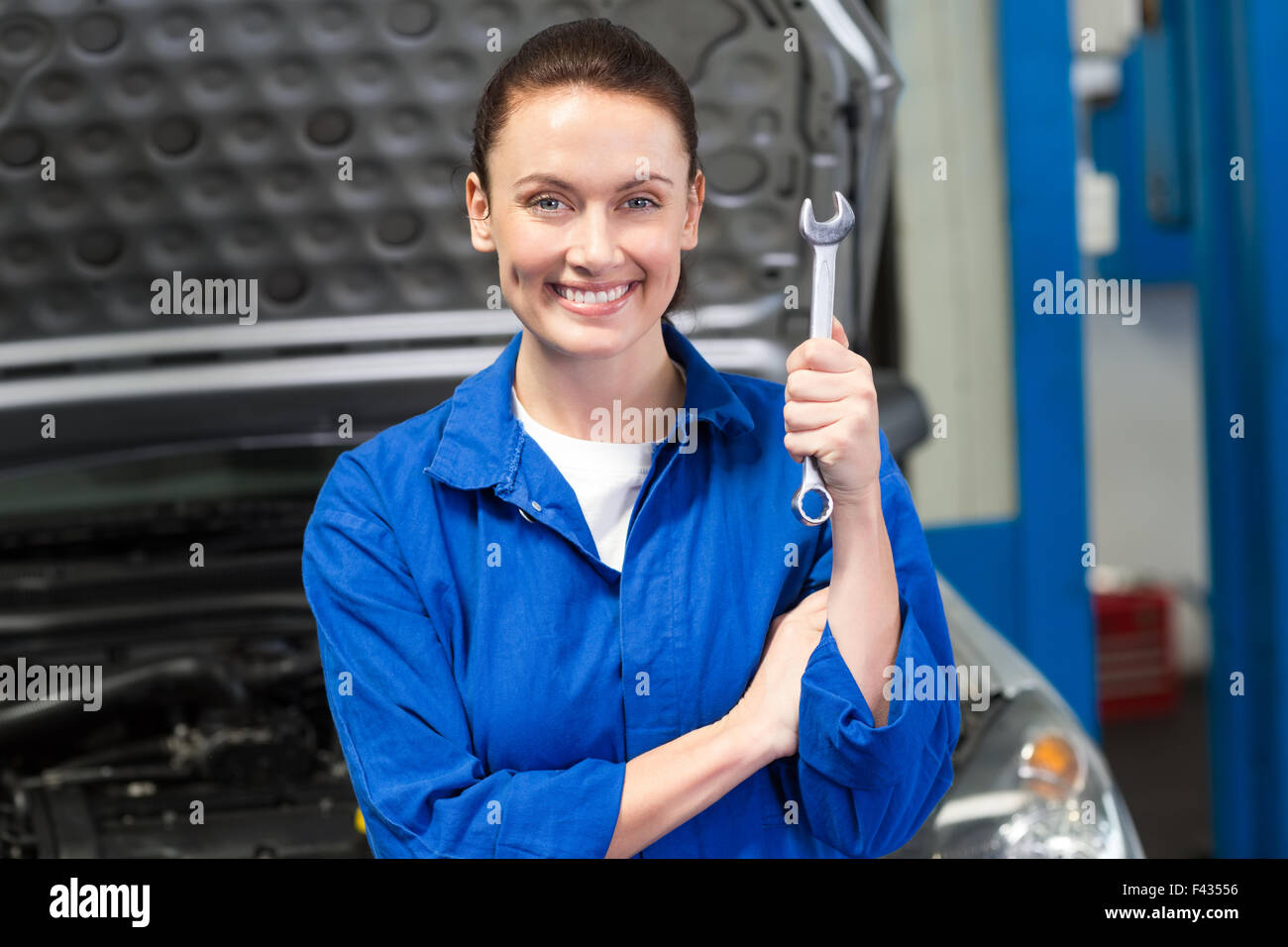 Smiling mechanic showing a wrench Stock Photo - Alamy