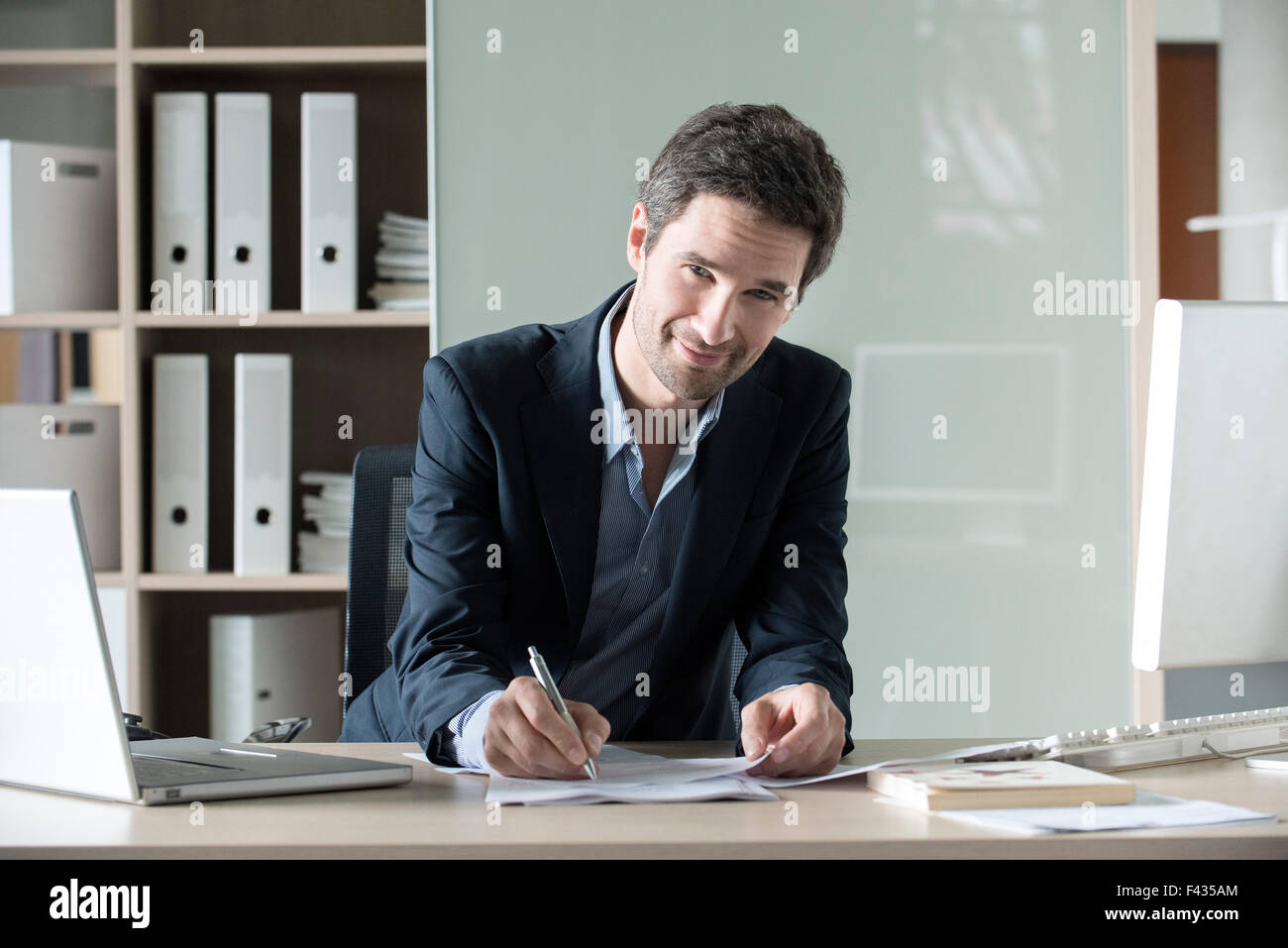 Businessman completing paperwork Stock Photo - Alamy
