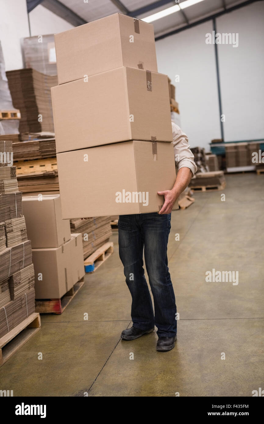 Worker carrying boxes in warehouse Stock Photo - Alamy