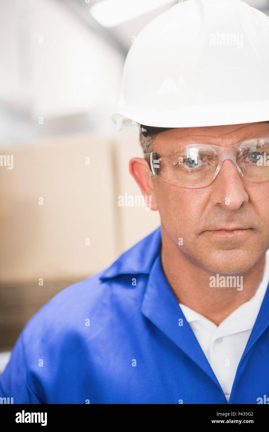 Worker wearing hard hat in warehouse Stock Photo - Alamy