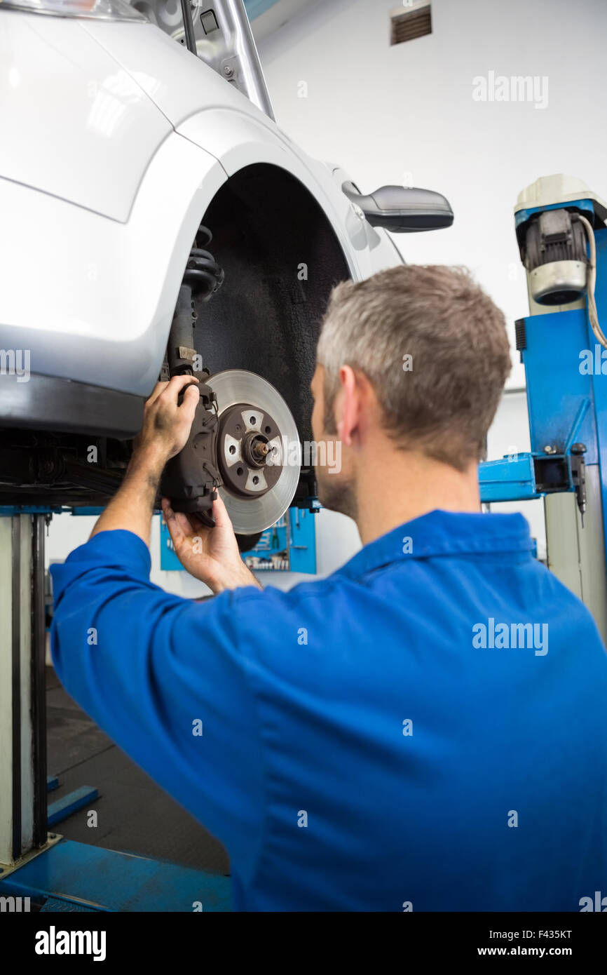Focused mechanic adjusting the wheel Stock Photo - Alamy