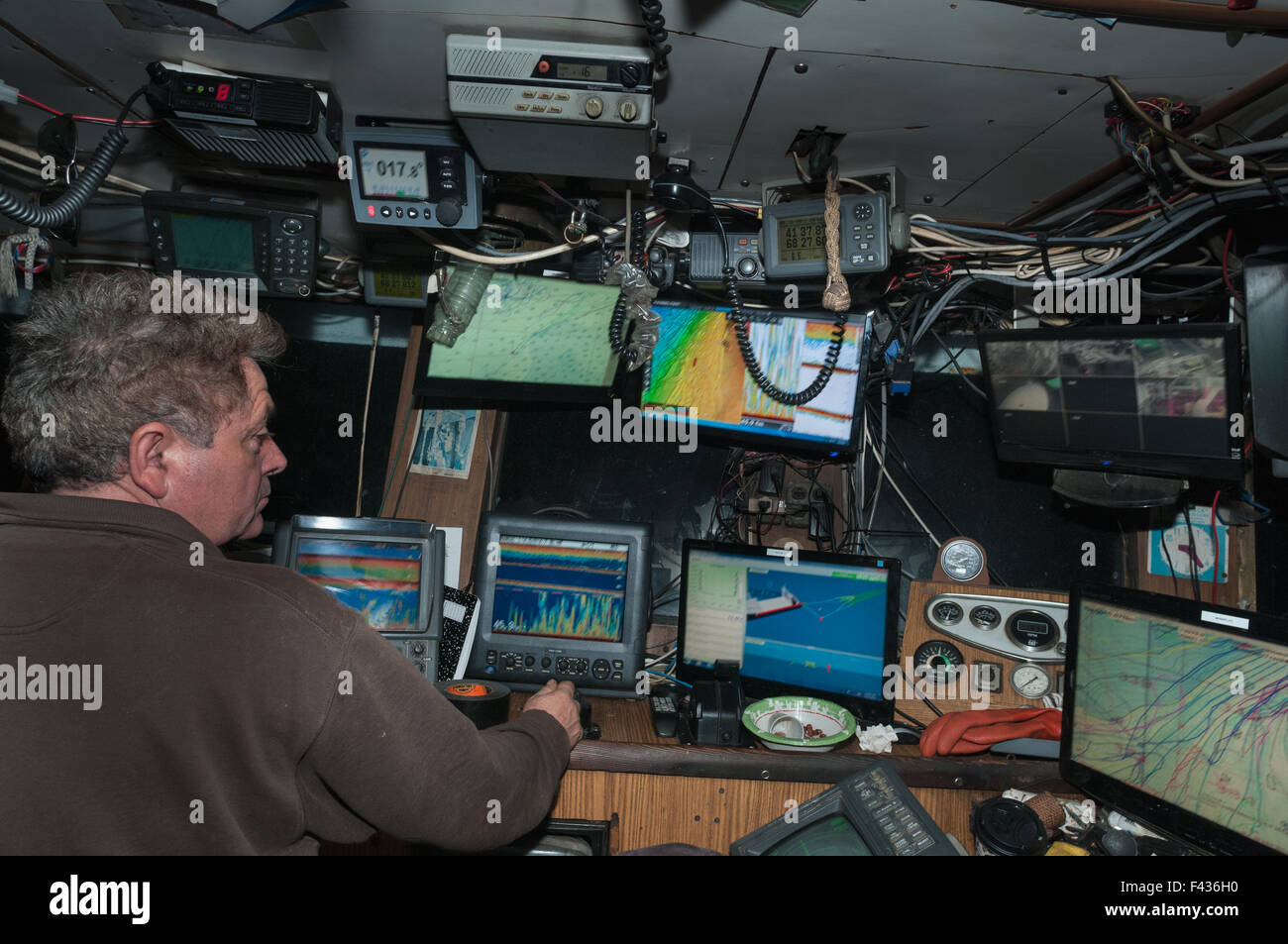Captain of offshore fishing trawler checks fishing and navigational ...