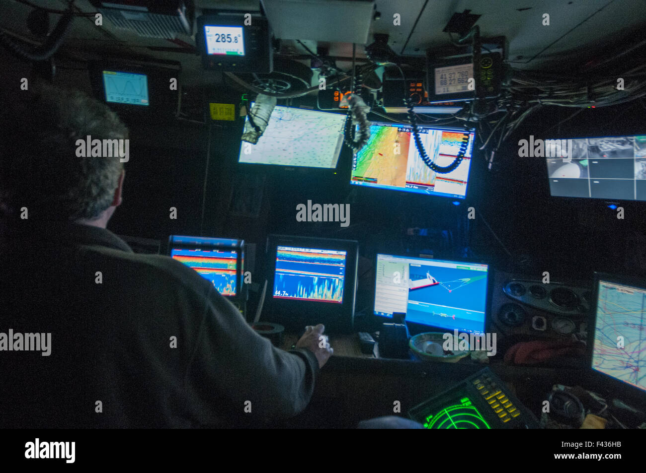 Captain of offshore fishing trawler checks fishing and navigational ...