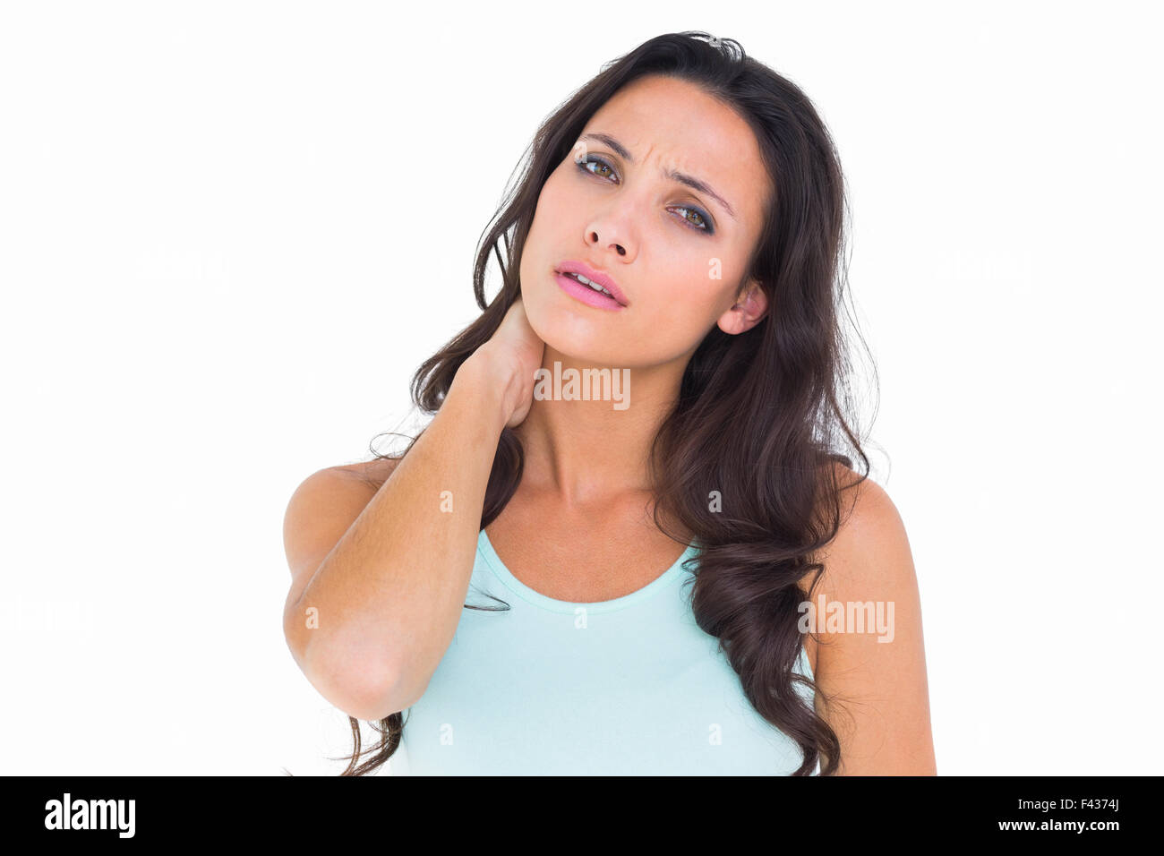 Pretty brunette with a sore neck Stock Photo - Alamy