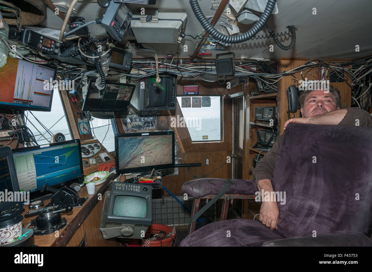 Captain of offshore fishing trawler checks fishing and navigational ...