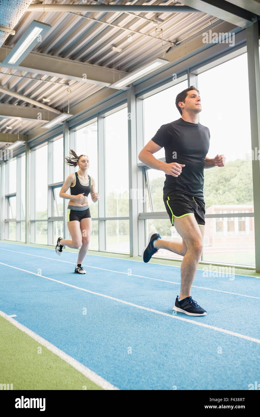 Couple running on the indoor track Stock Photo - Alamy