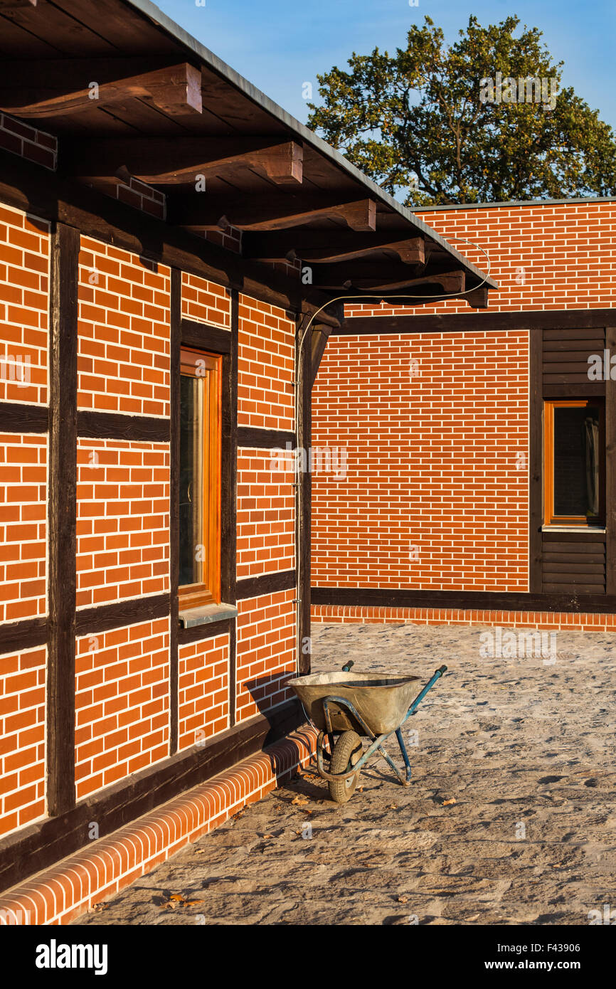 used wheelbarrow and renovated old buildnig Stock Photo - Alamy