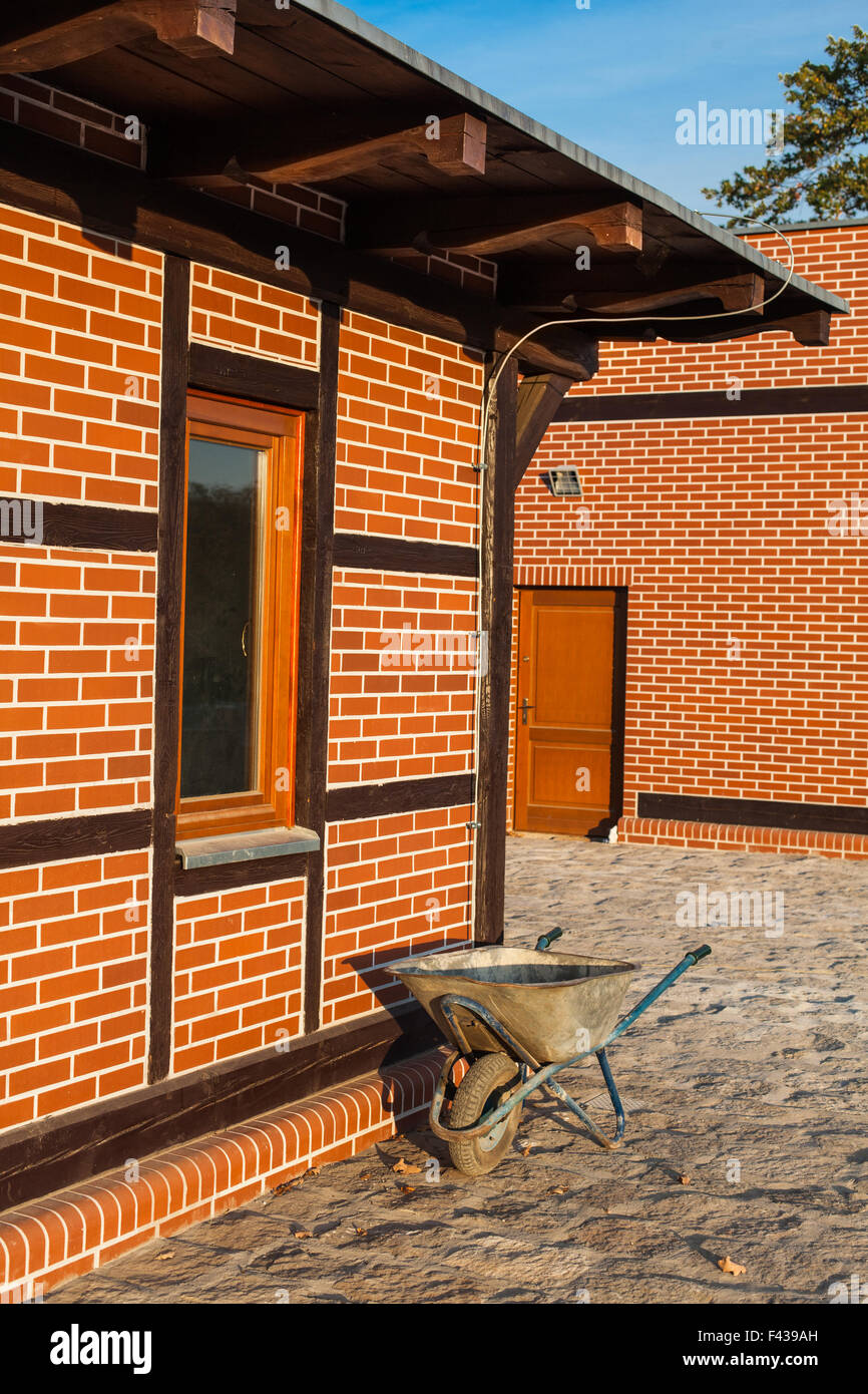 used wheelbarrow and renovated old buildnig Stock Photo - Alamy