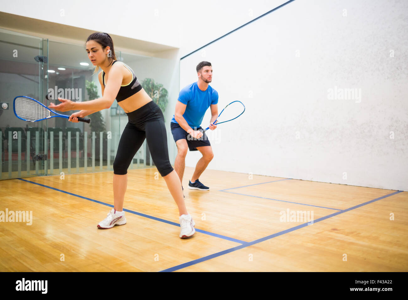Couple play some squash together Stock Photo - Alamy