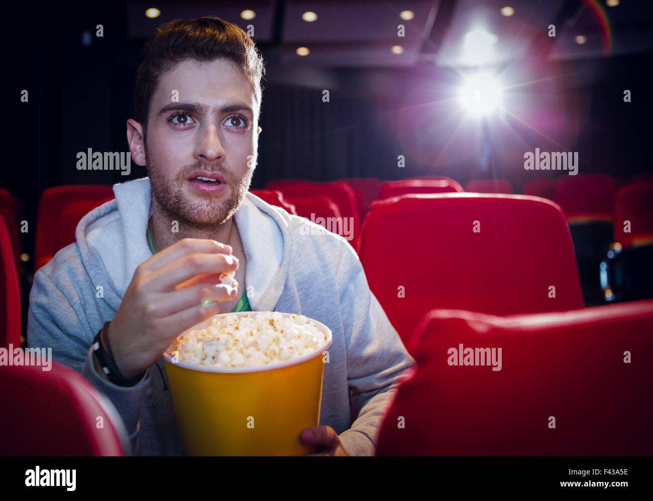 Young man watching a film Stock Photo - Alamy
