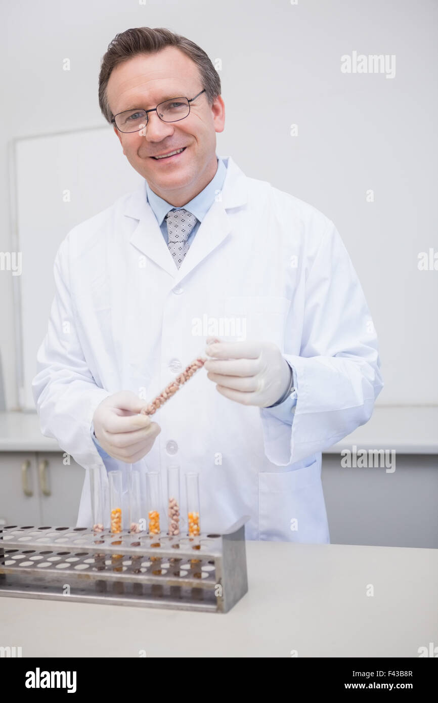 Happy scientist holding kernel in tube Stock Photo - Alamy