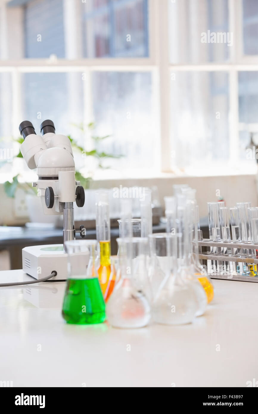 Beakers with chemical fluid and microscope Stock Photo - Alamy