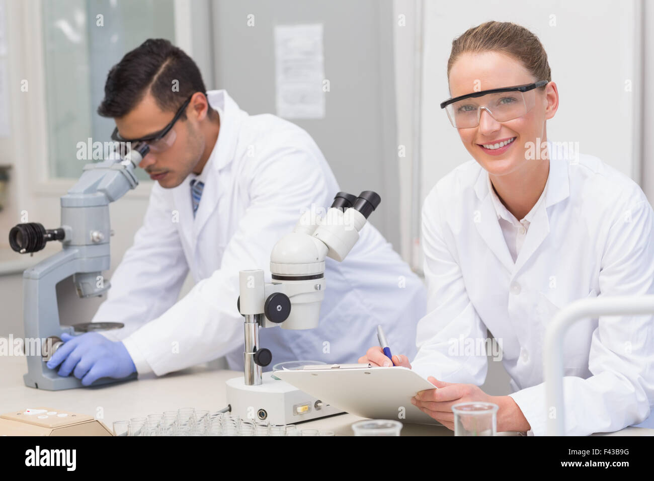 Scientists using microscope Stock Photo - Alamy