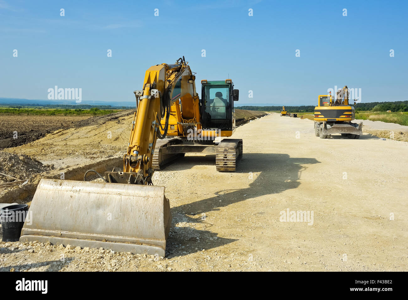 Excavator on road construction Stock Photo - Alamy