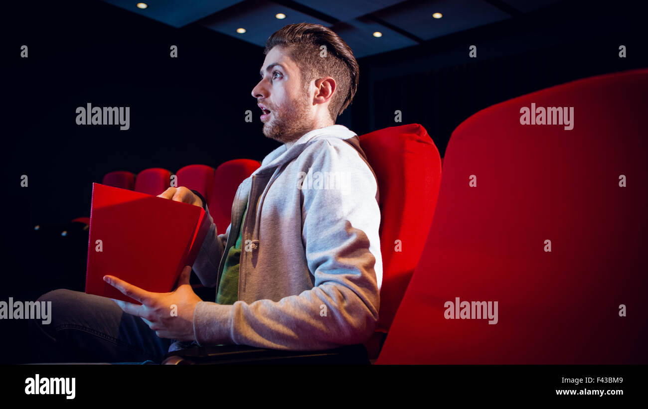Young man watching a film Stock Photo - Alamy