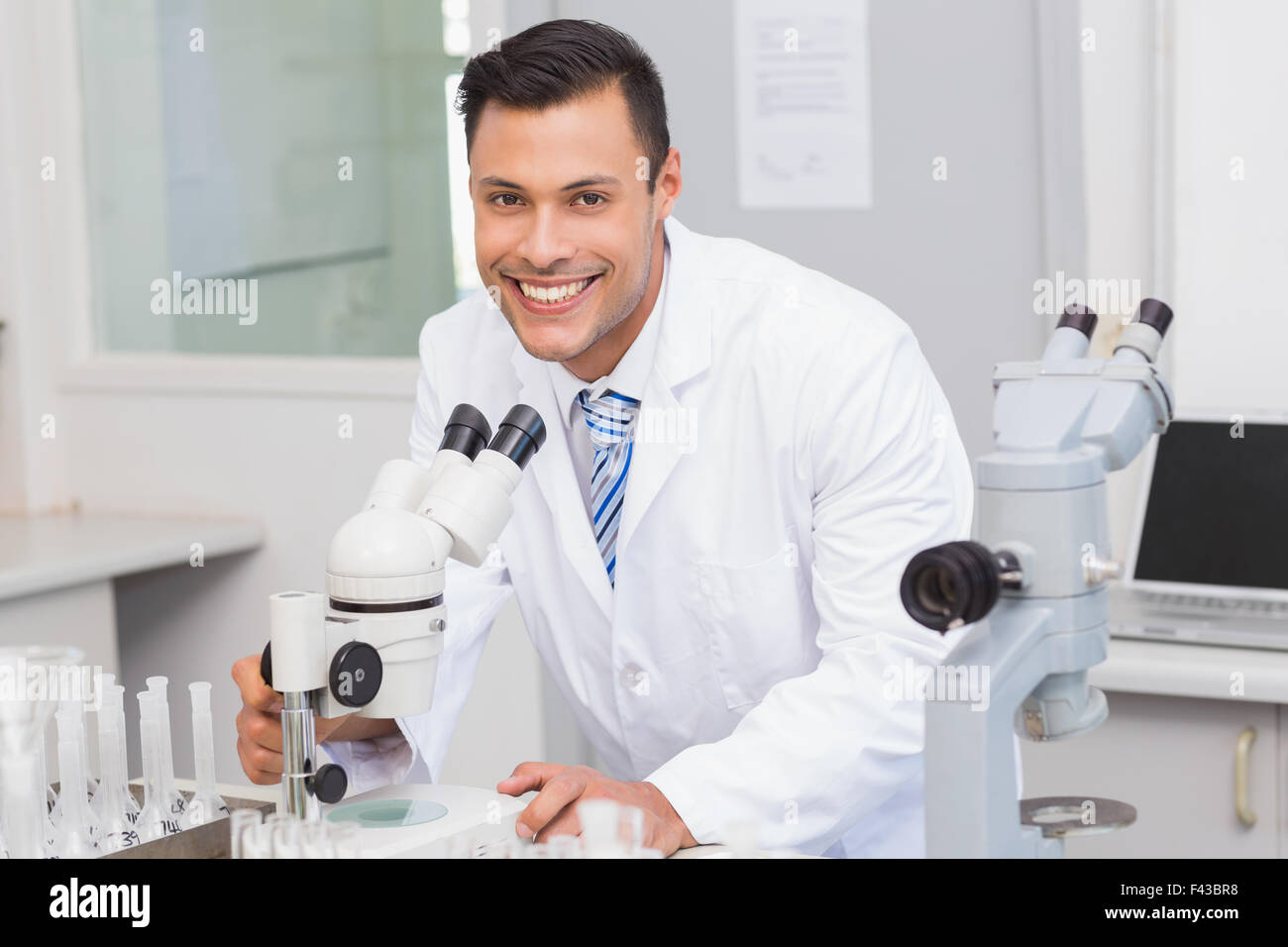 Happy scientist using microscope Stock Photo - Alamy