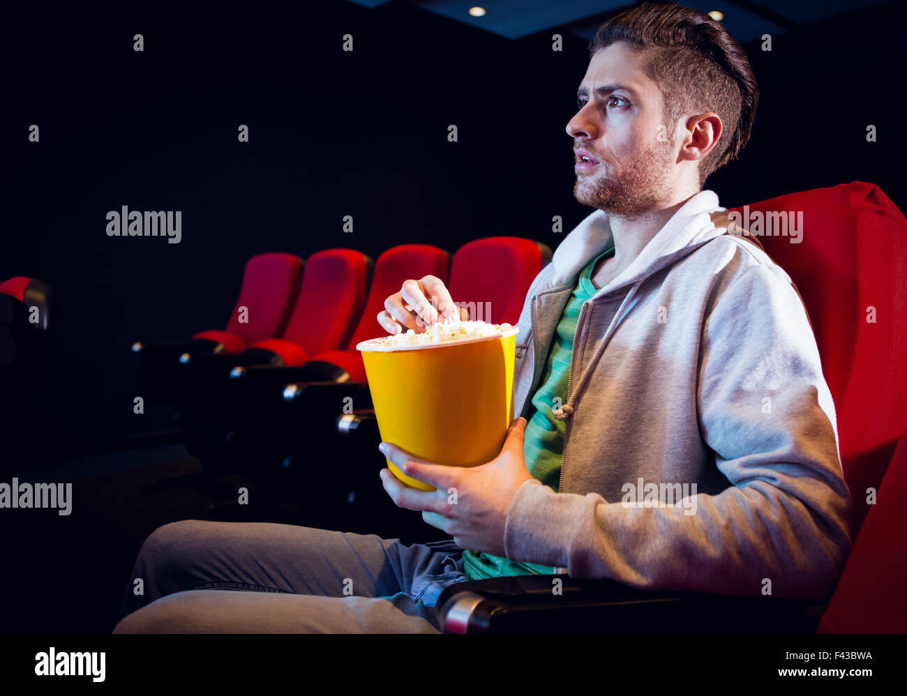 Young man watching a film Stock Photo - Alamy