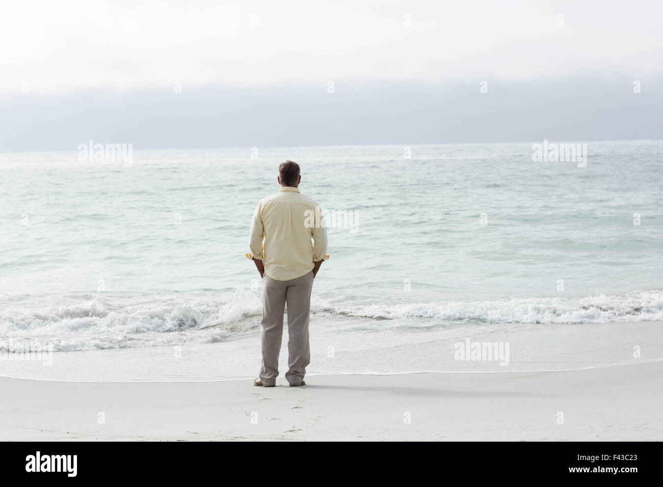 Thoughtful man standing by the sea Stock Photo - Alamy
