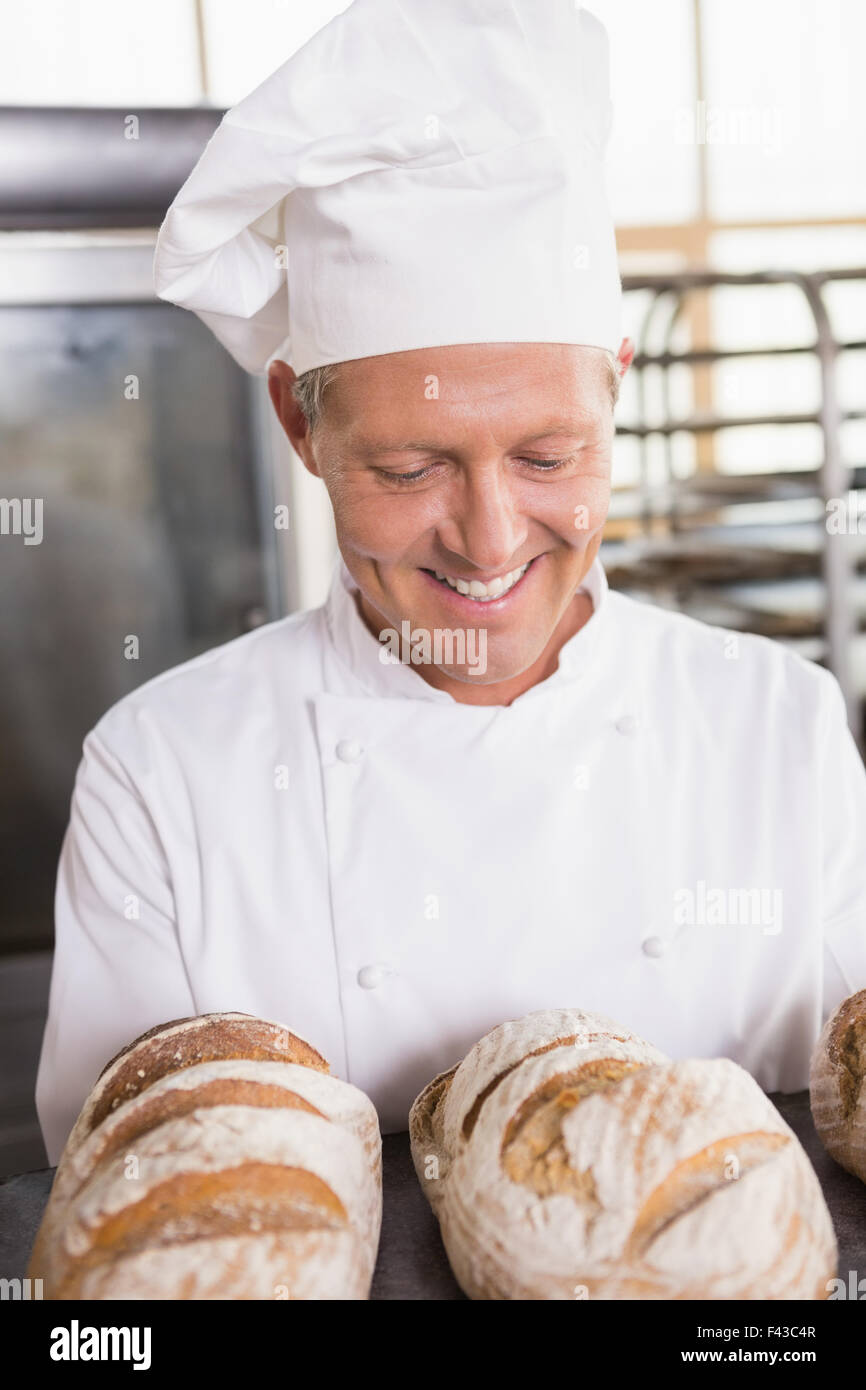Happy baker showing tray of fresh bread Stock Photo - Alamy