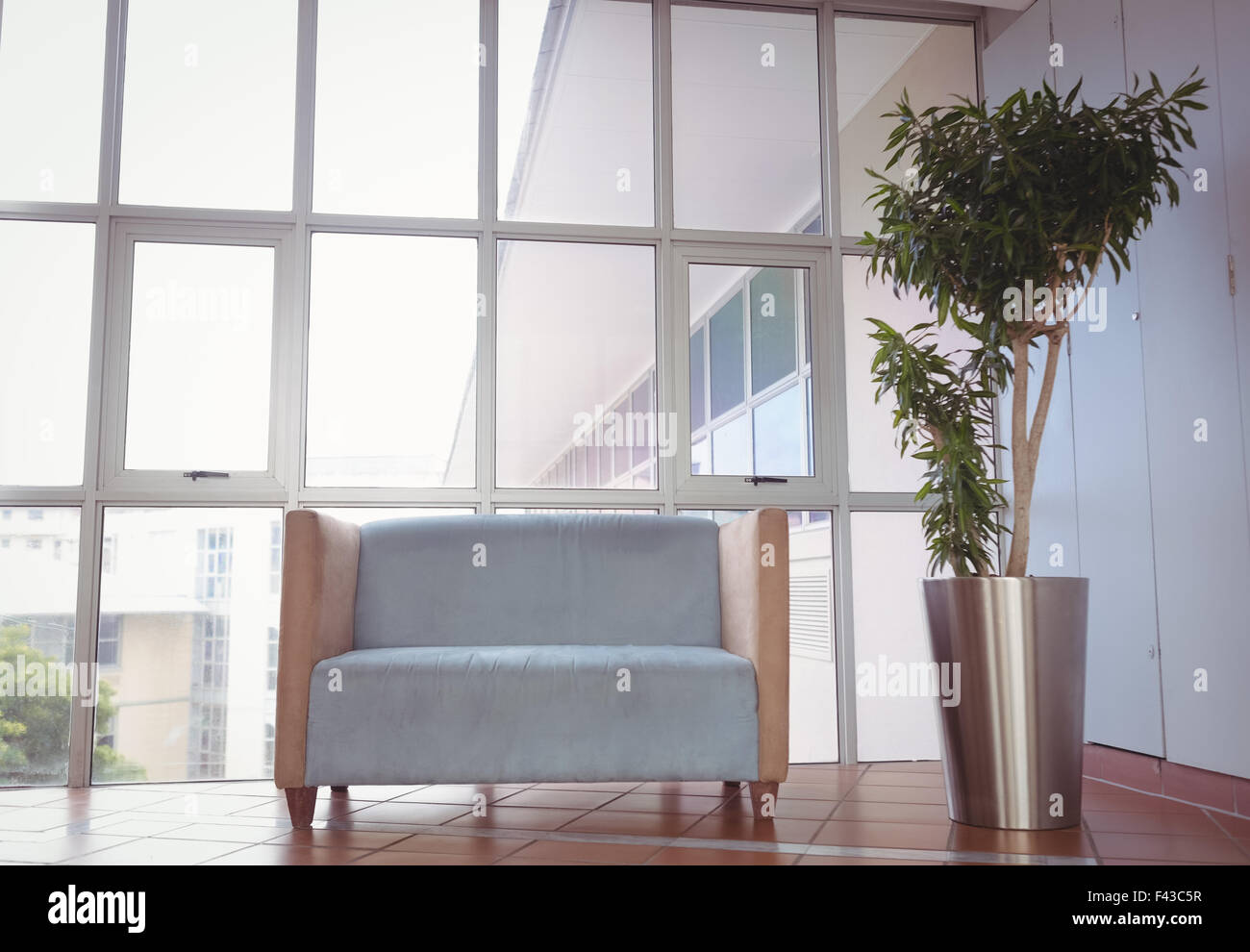 Reception area with couch and window Stock Photo - Alamy