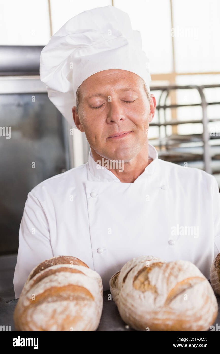 Baker smelling freshly baked breads Stock Photo - Alamy