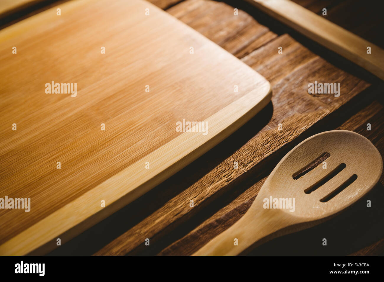 Chopping board with wooden utensils Stock Photo - Alamy