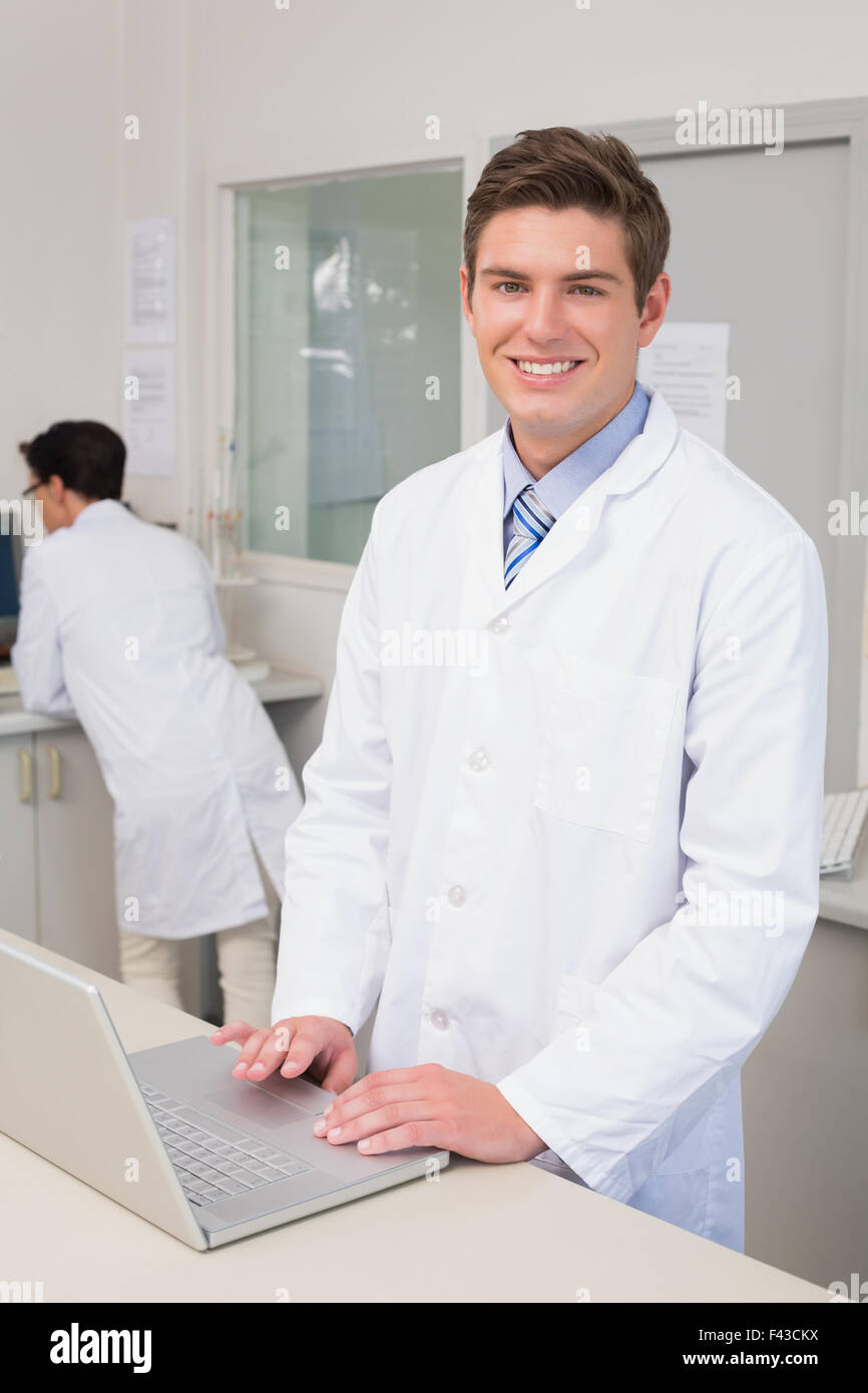 Smiling scientist using laptop Stock Photo - Alamy