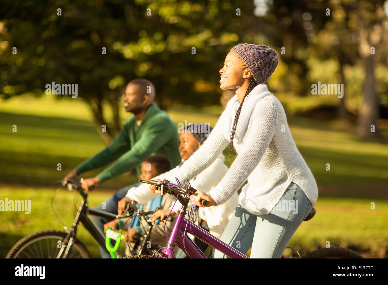Side view of a young family doing a bike ride Stock Photo - Alamy