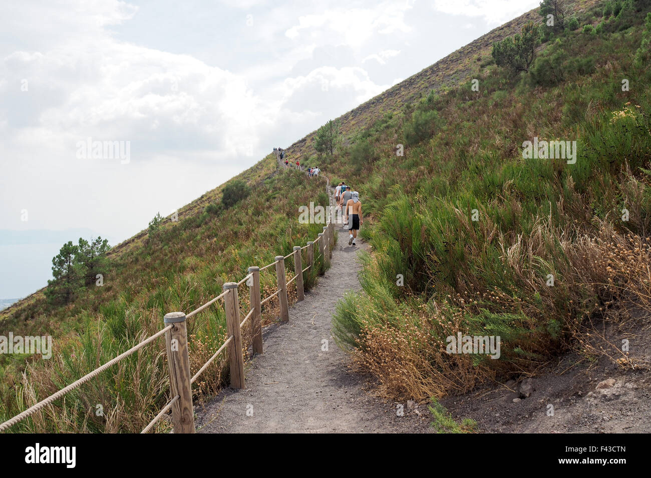 Tourists walking along a track to the peak of the volcano, Mount ...