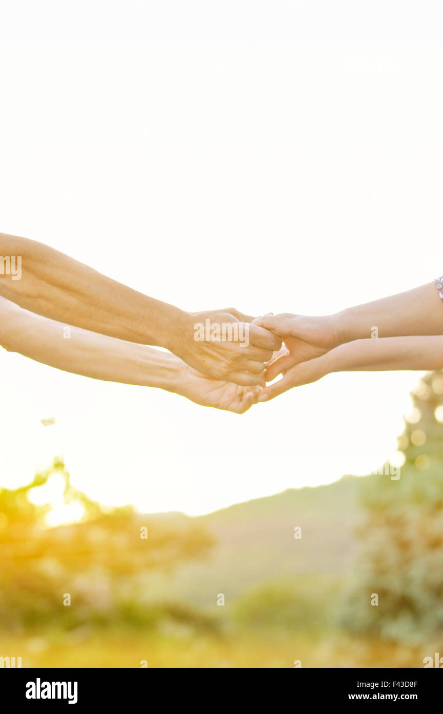 Couple in love holding hands at sunset hi-res stock photography and ...