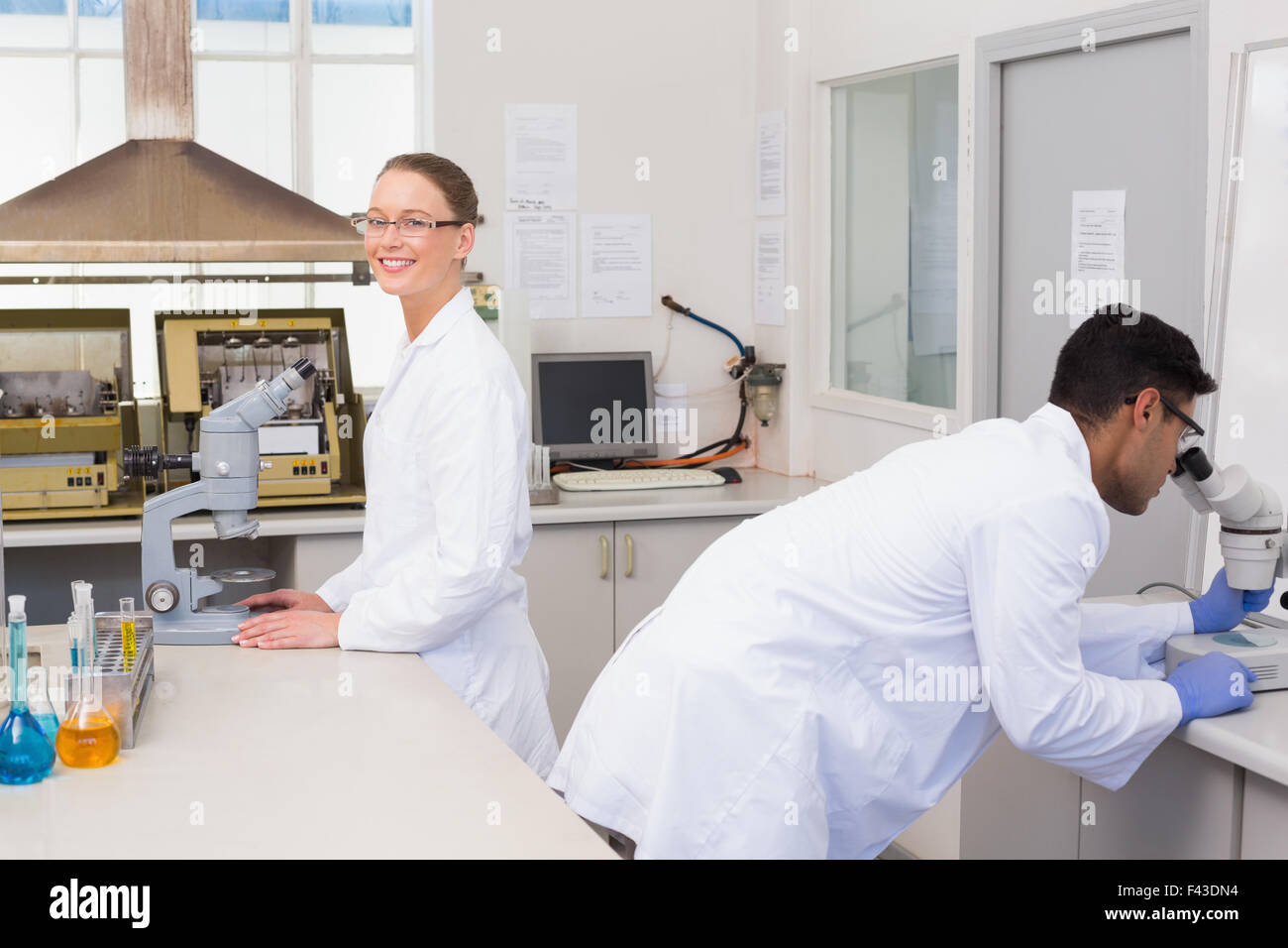 Scientists using microscope Stock Photo - Alamy