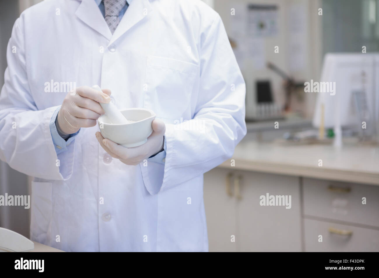 Scientist grinding powder with mortar Stock Photo - Alamy