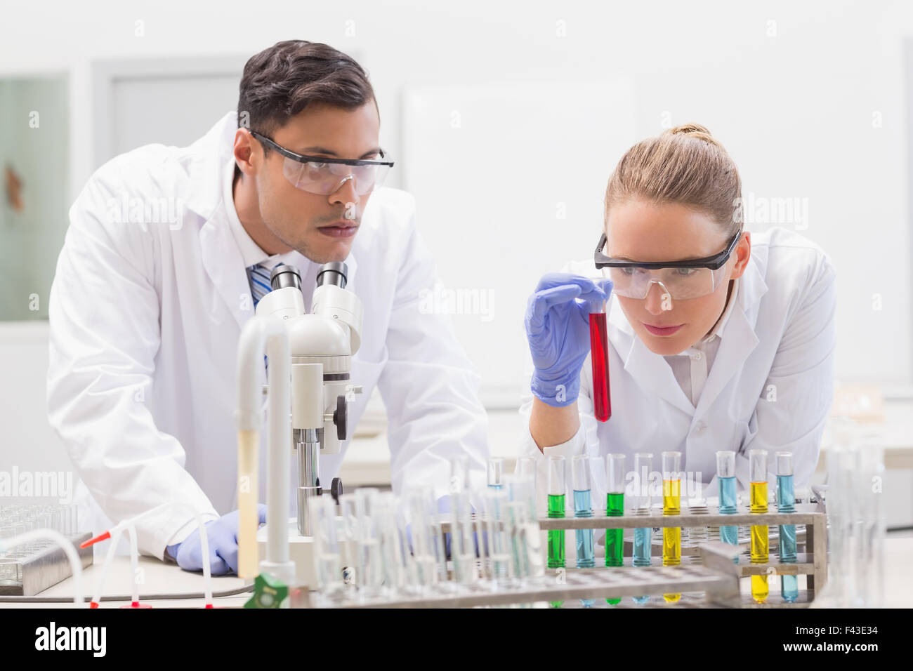 Scientists examining tubes Stock Photo - Alamy