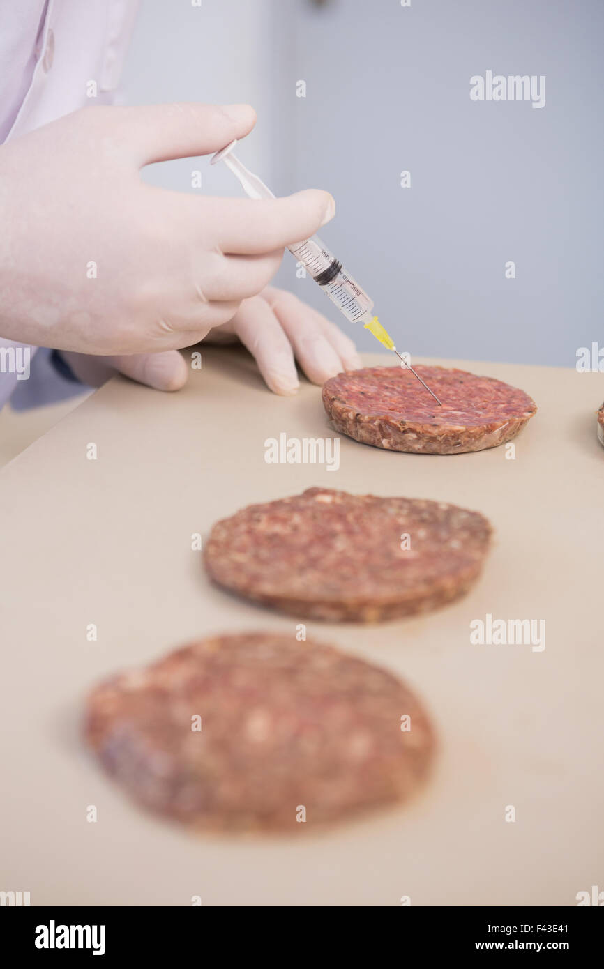 Scientist injecting beefsteaks Stock Photo - Alamy