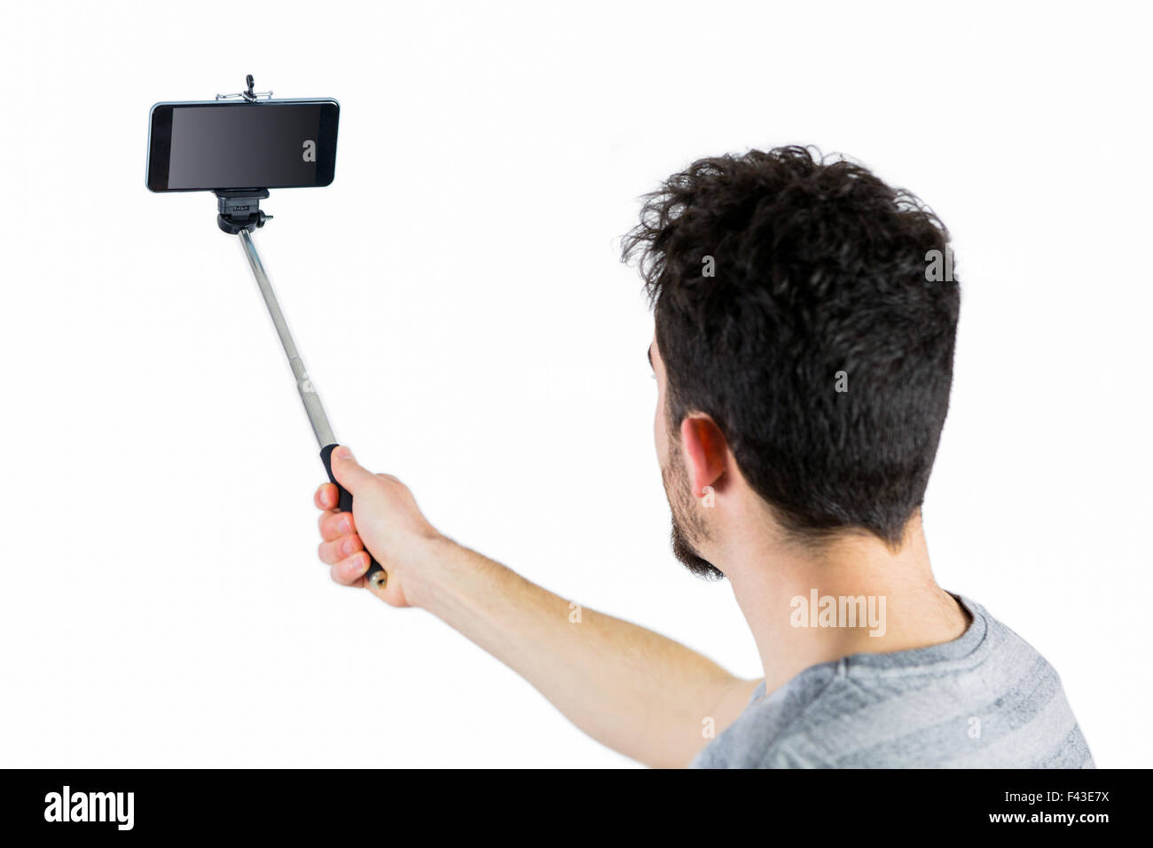 Casual man using a selfie stick Stock Photo - Alamy