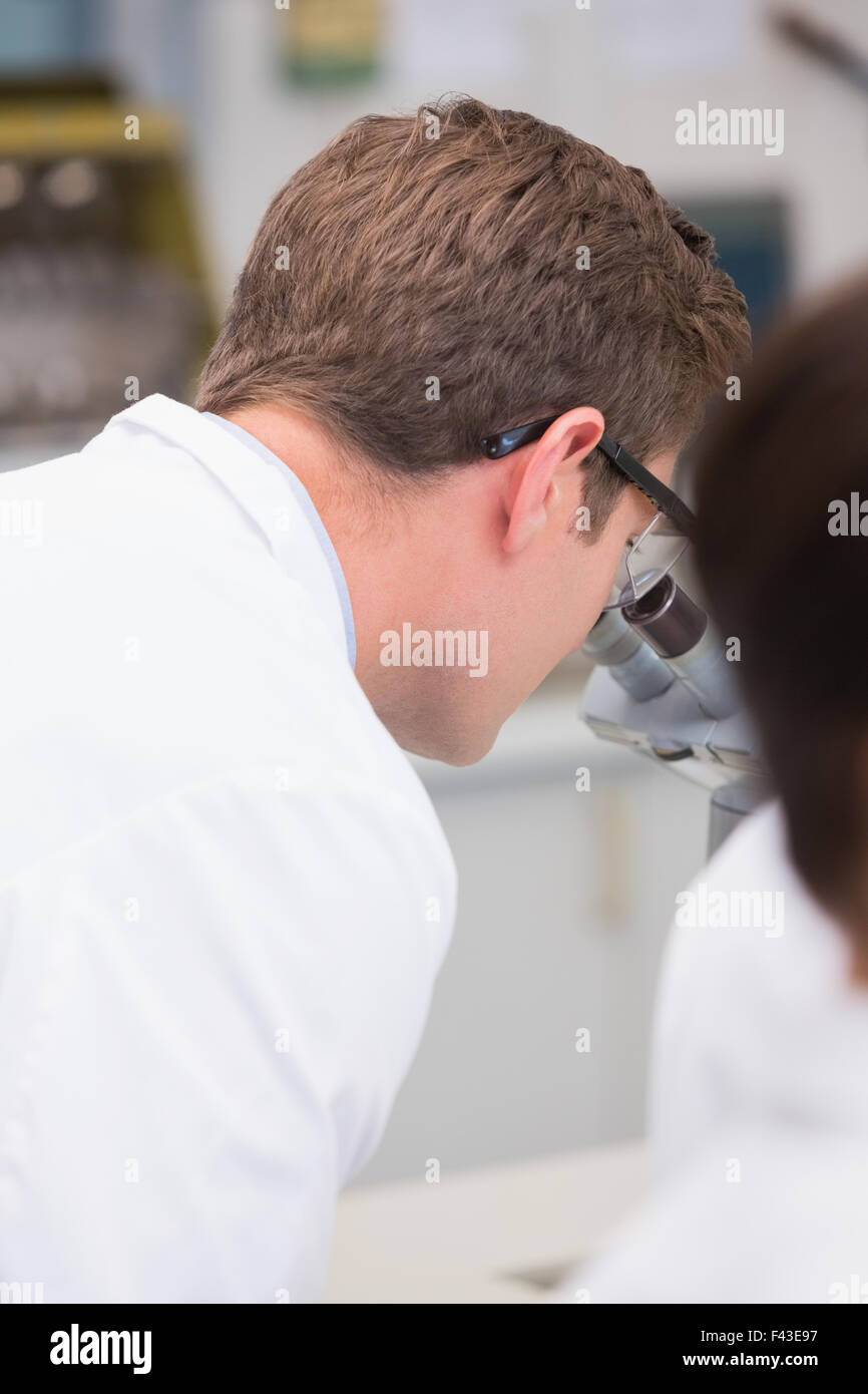 Scientist looking through a microscope Stock Photo - Alamy